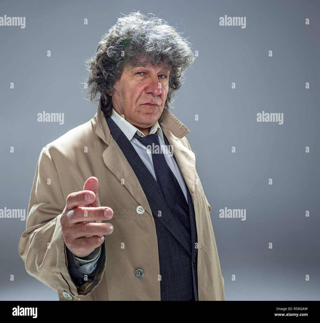 The senior man as detective or boss of mafia on gray studio background ...