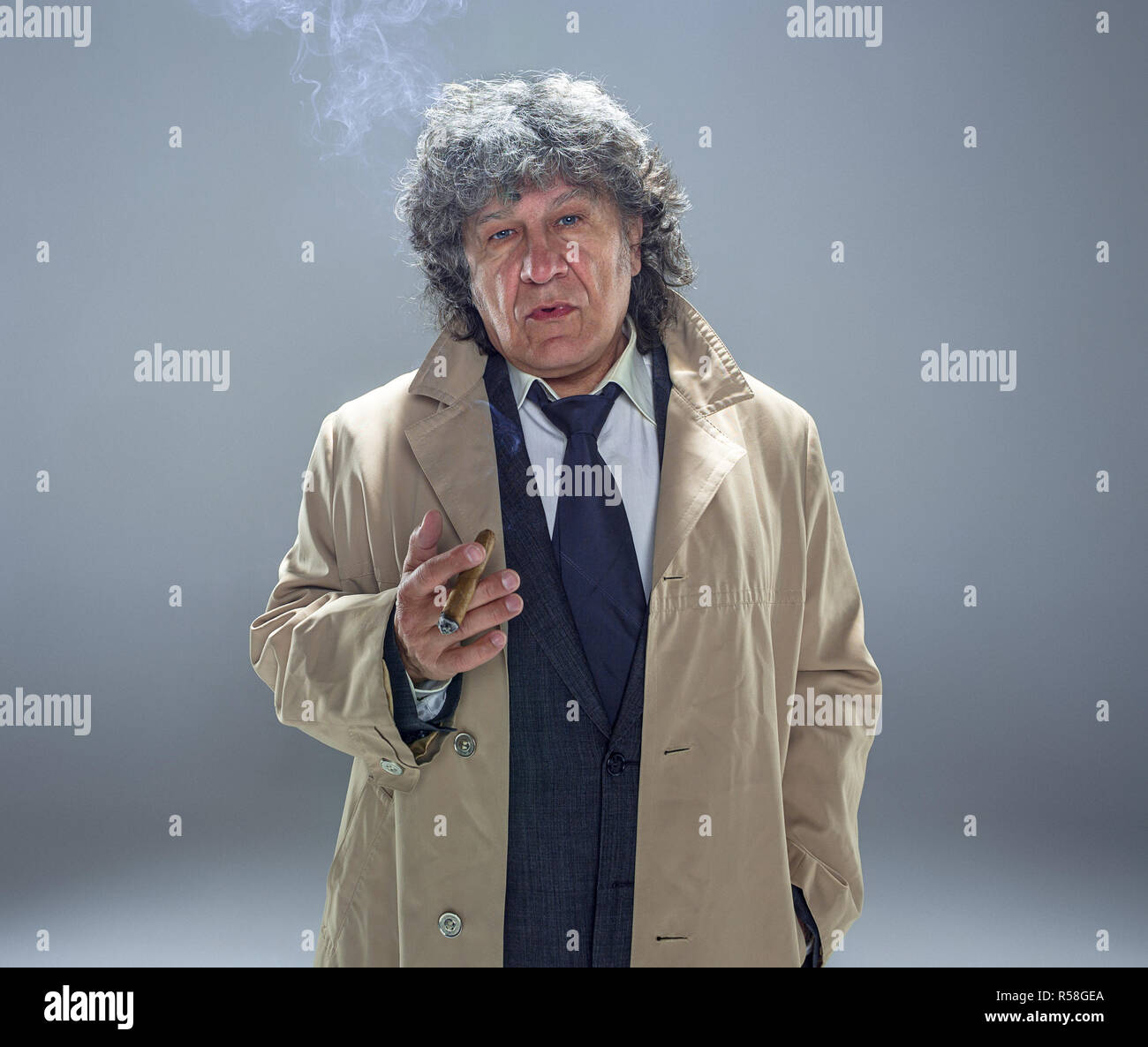 The senior man with cigar as detective or boss of mafia on gray studio ...