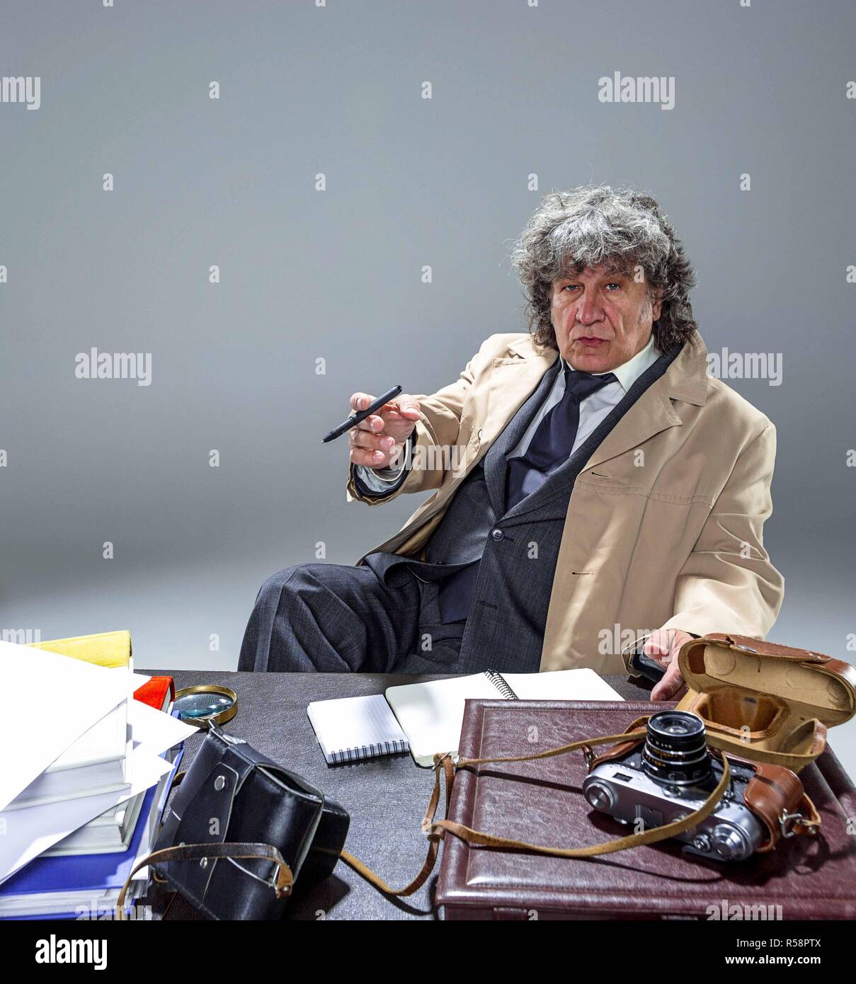 The senior man as detective or boss of mafia on gray studio background ...