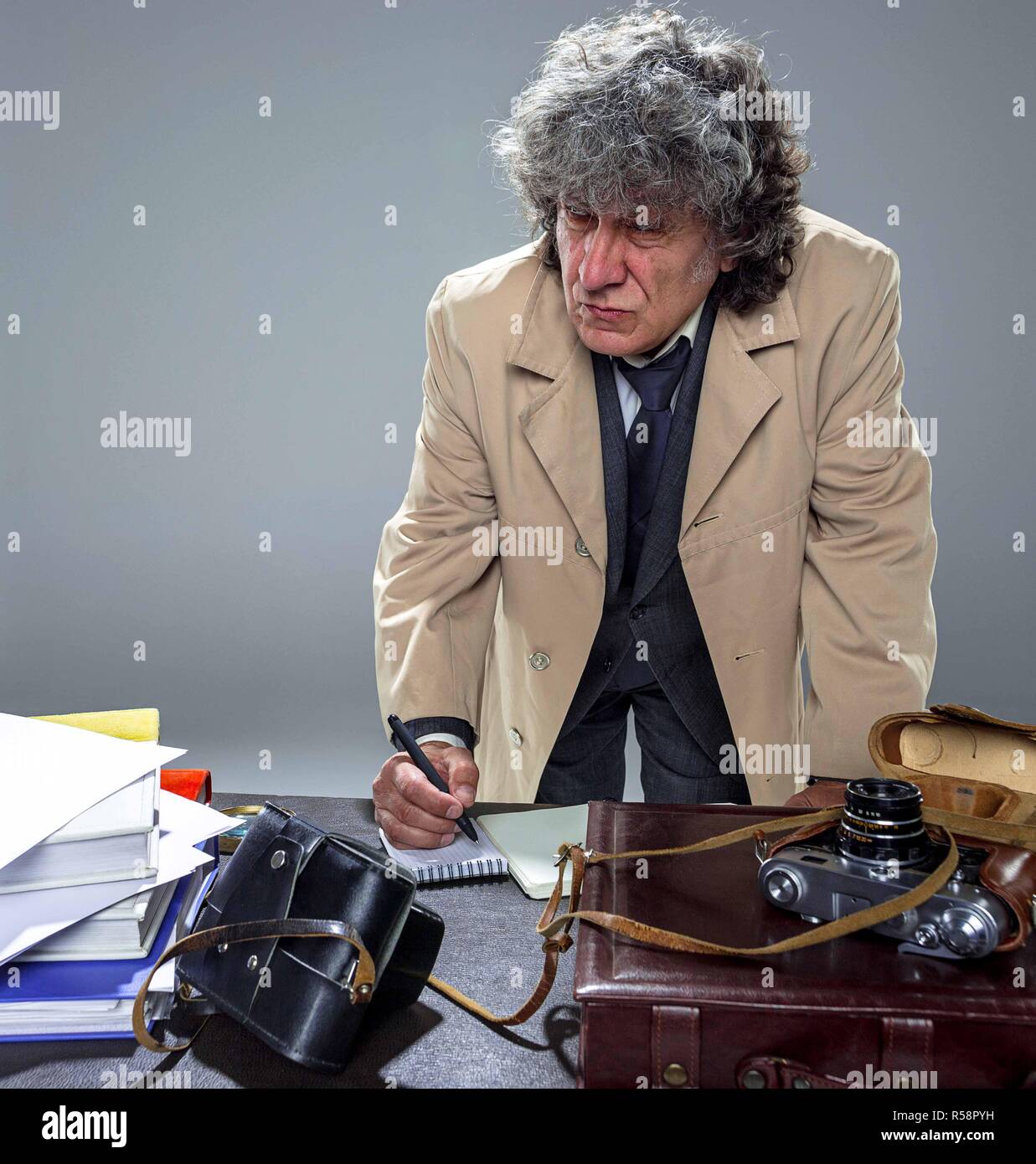 The senior man as detective or boss of mafia on gray studio background ...