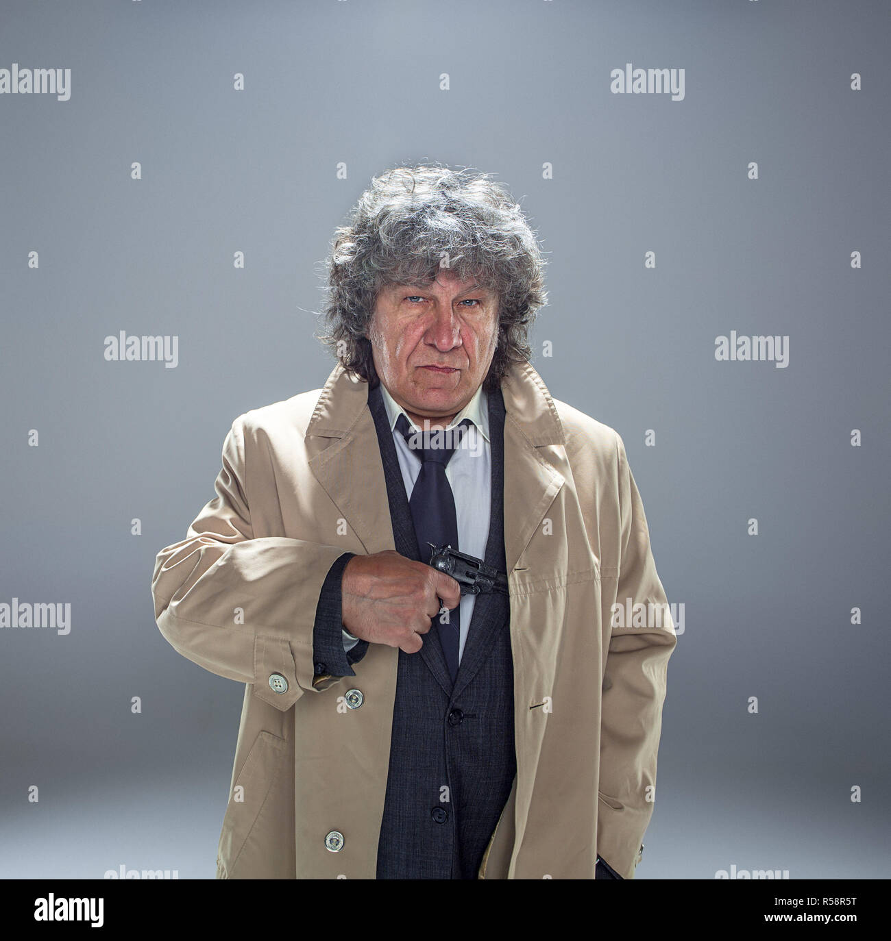 Senior police agent with a gun on studio background Stock Photo - Alamy