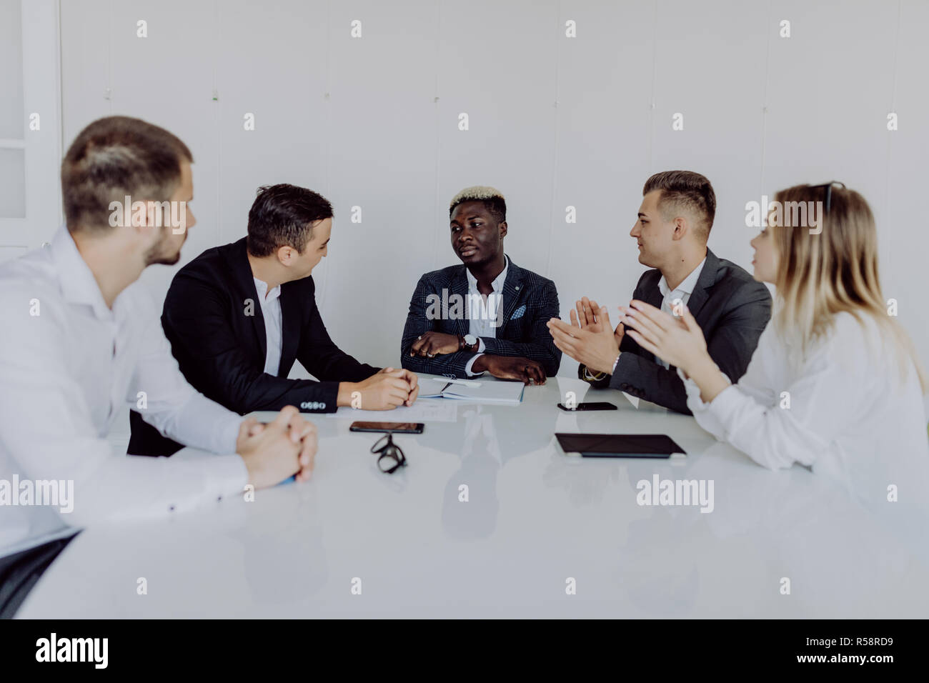 Multiracial business people applauding sitting at conference table ... Multiracial business people applauding sitting at conference table ...