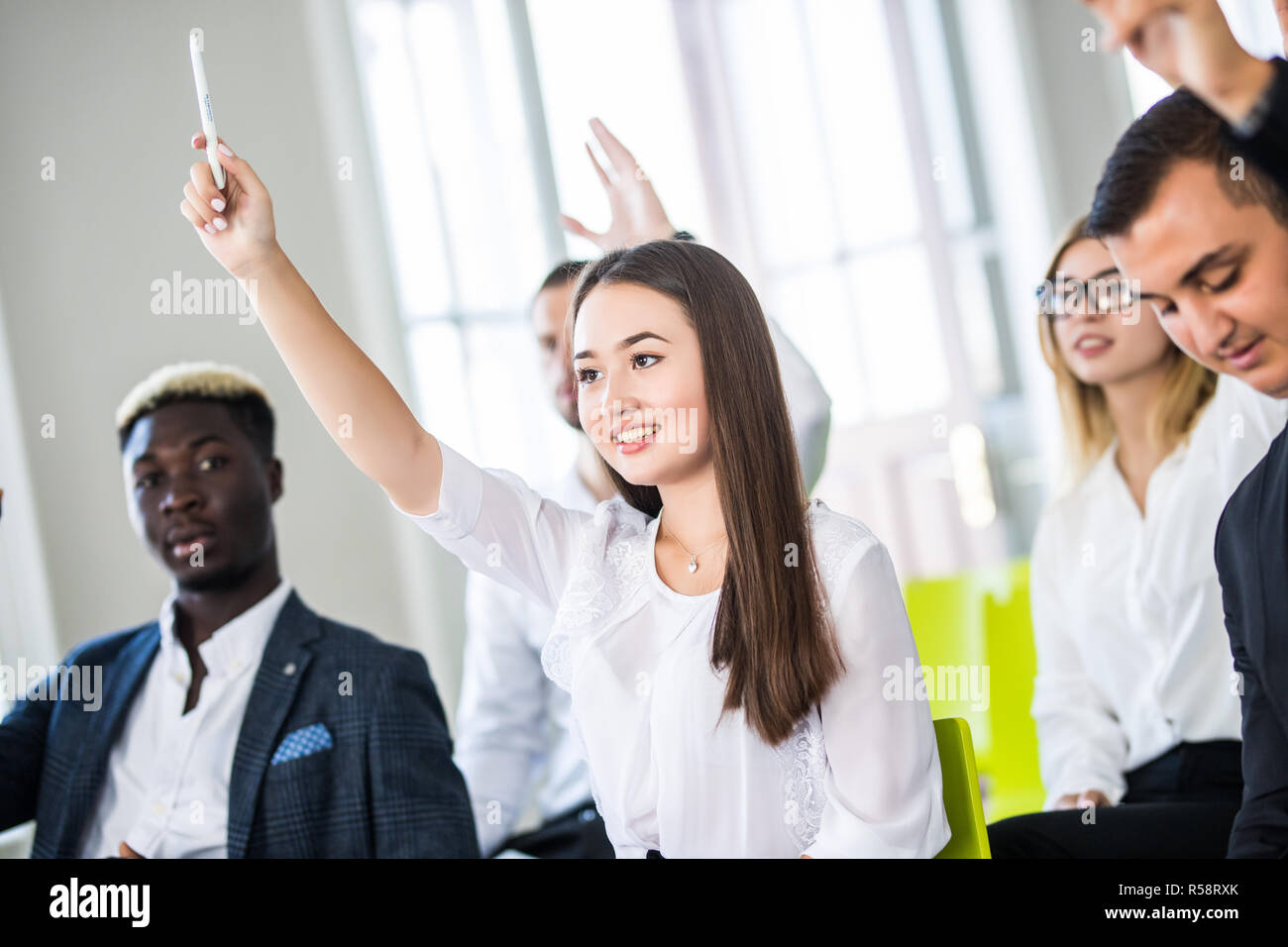 Group of business people raise hands up to agree with speaker in the ...