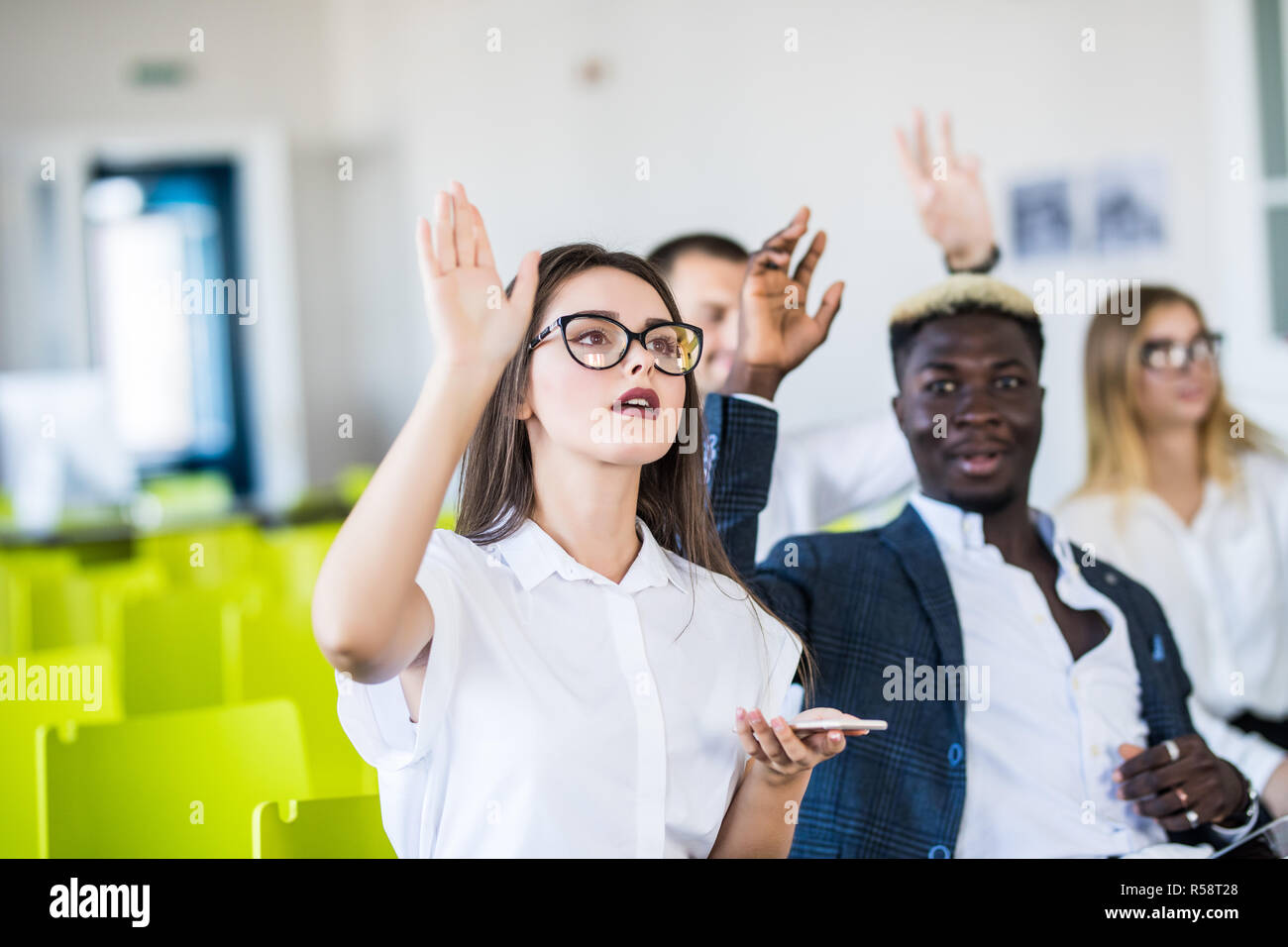 Seminar group raising up hand for asking the speaker in question and ...