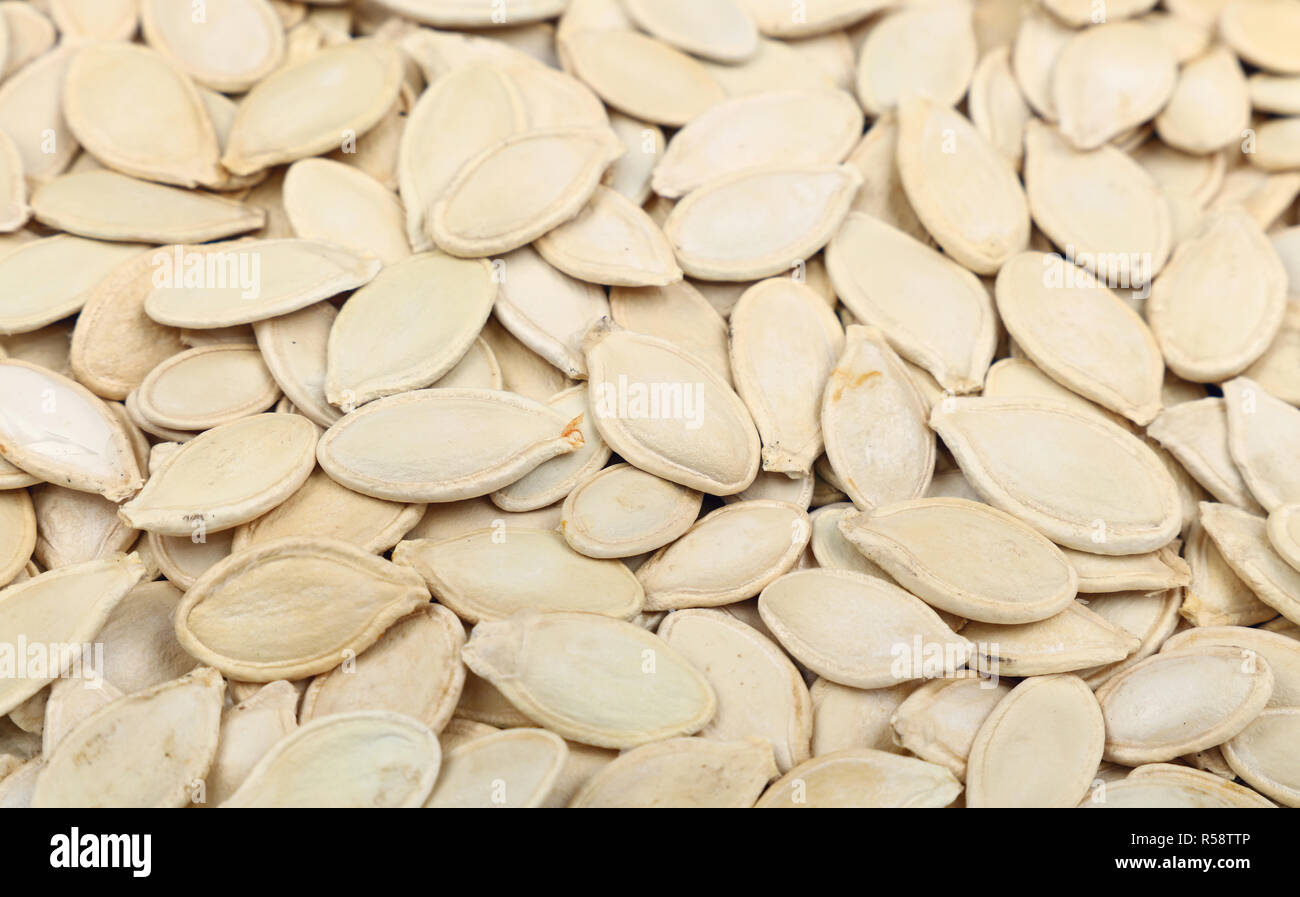 Raw pumpkin seeds close up background Stock Photo - Alamy