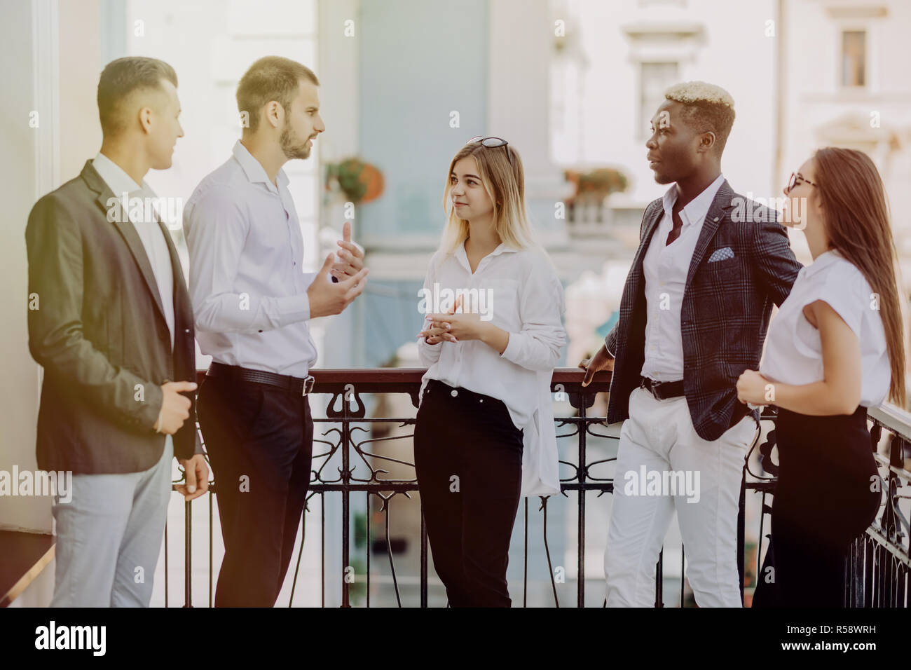 Business people having coffee break at the balcony of office building ...