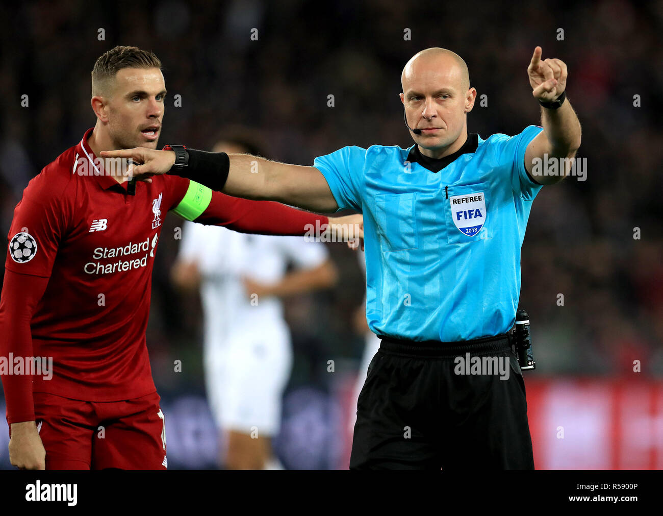 Liverpool's Jordan Henderson speaks with match referee Szymon Marciniak ...