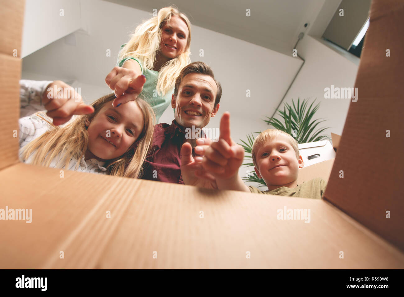 Image of parents and children looking inside cardboard box Stock Photo ...