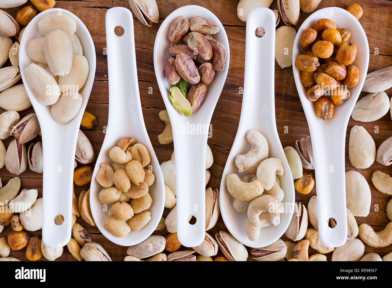 Closeup of mix of nuts over a rustic table Stock Photo - Alamy