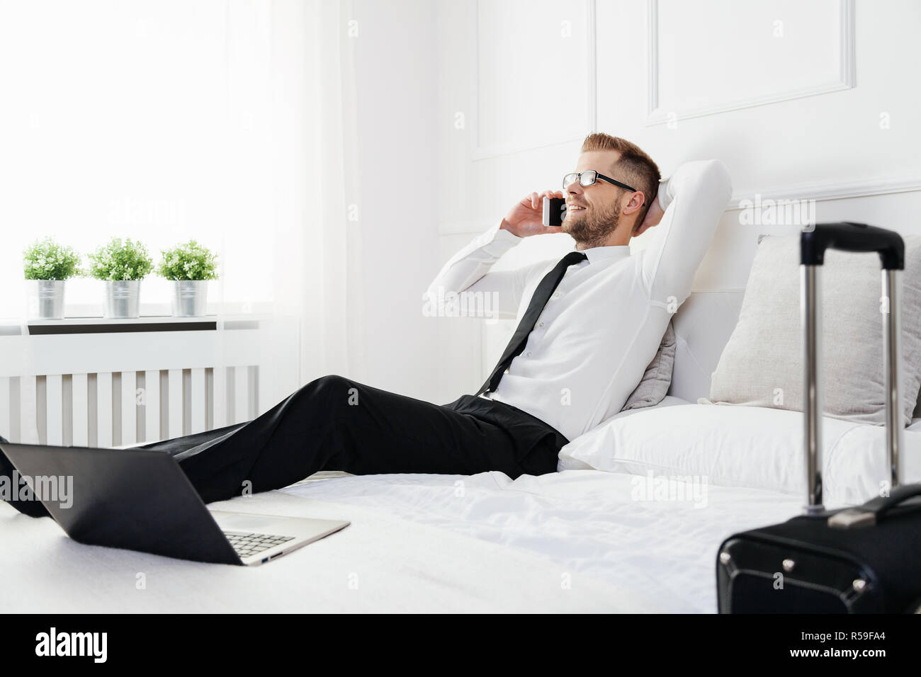 Businessman working from a hotel room with his mobile phone Stock Photo ...