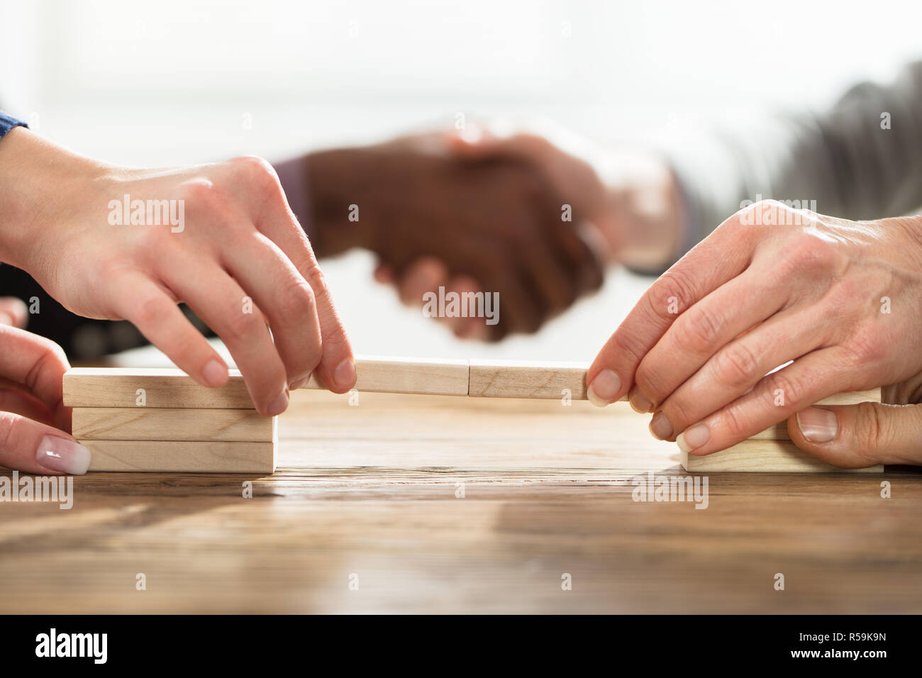 Businesspeople Building Bridge With Wooden Blocks Stock Photo - Alamy