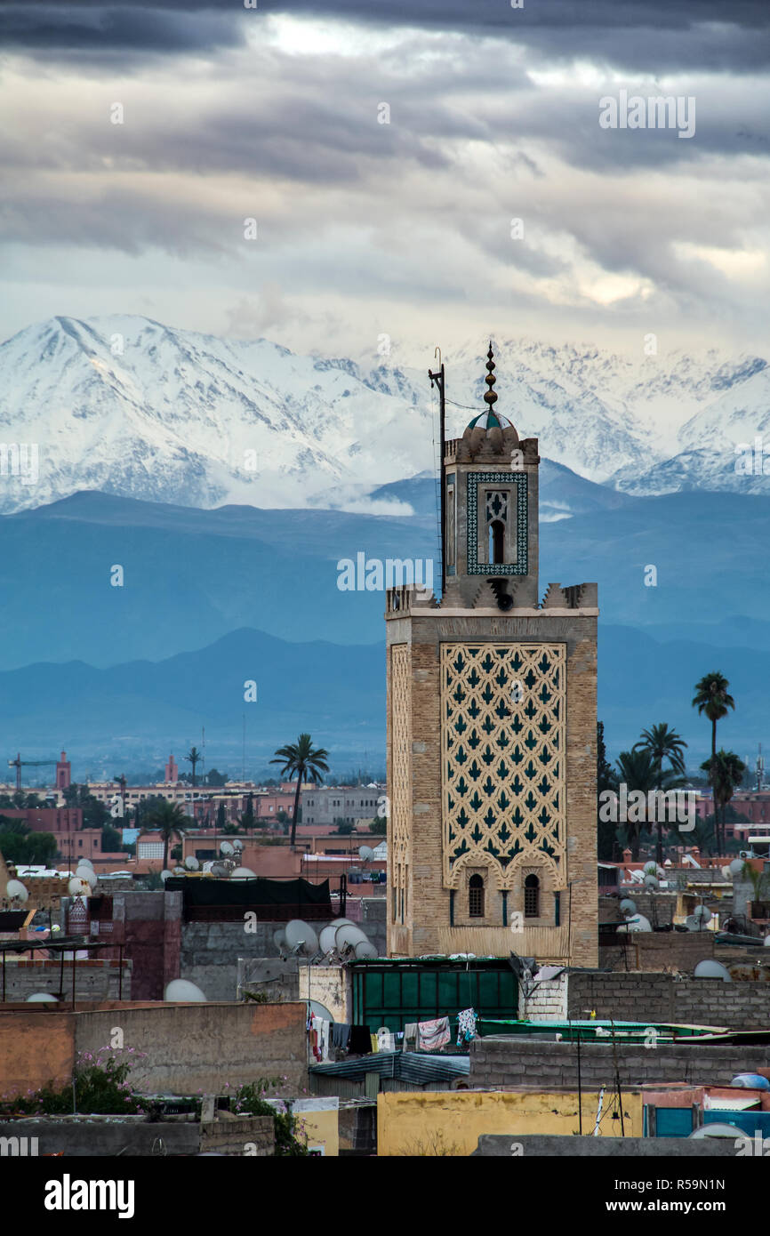 Marrakesh mosque standing tall against backdrop of Atlas mountains ...