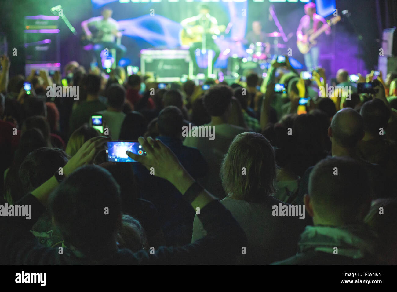 Concert crowd with arms raised, silhouettes of people with smartphones ...
