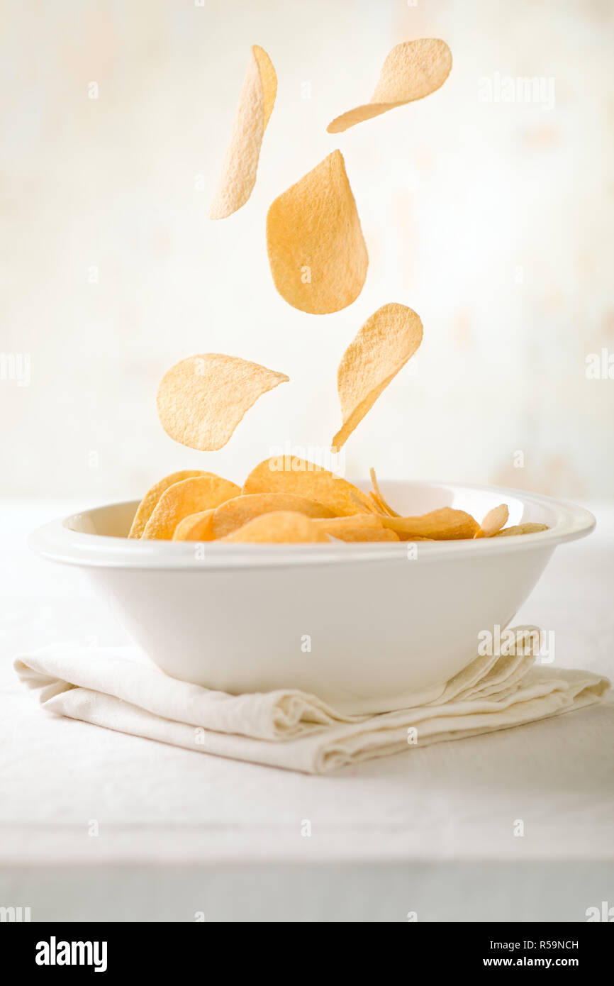 Potato Chips Falling in a White Bowl Stock Photo - Alamy
