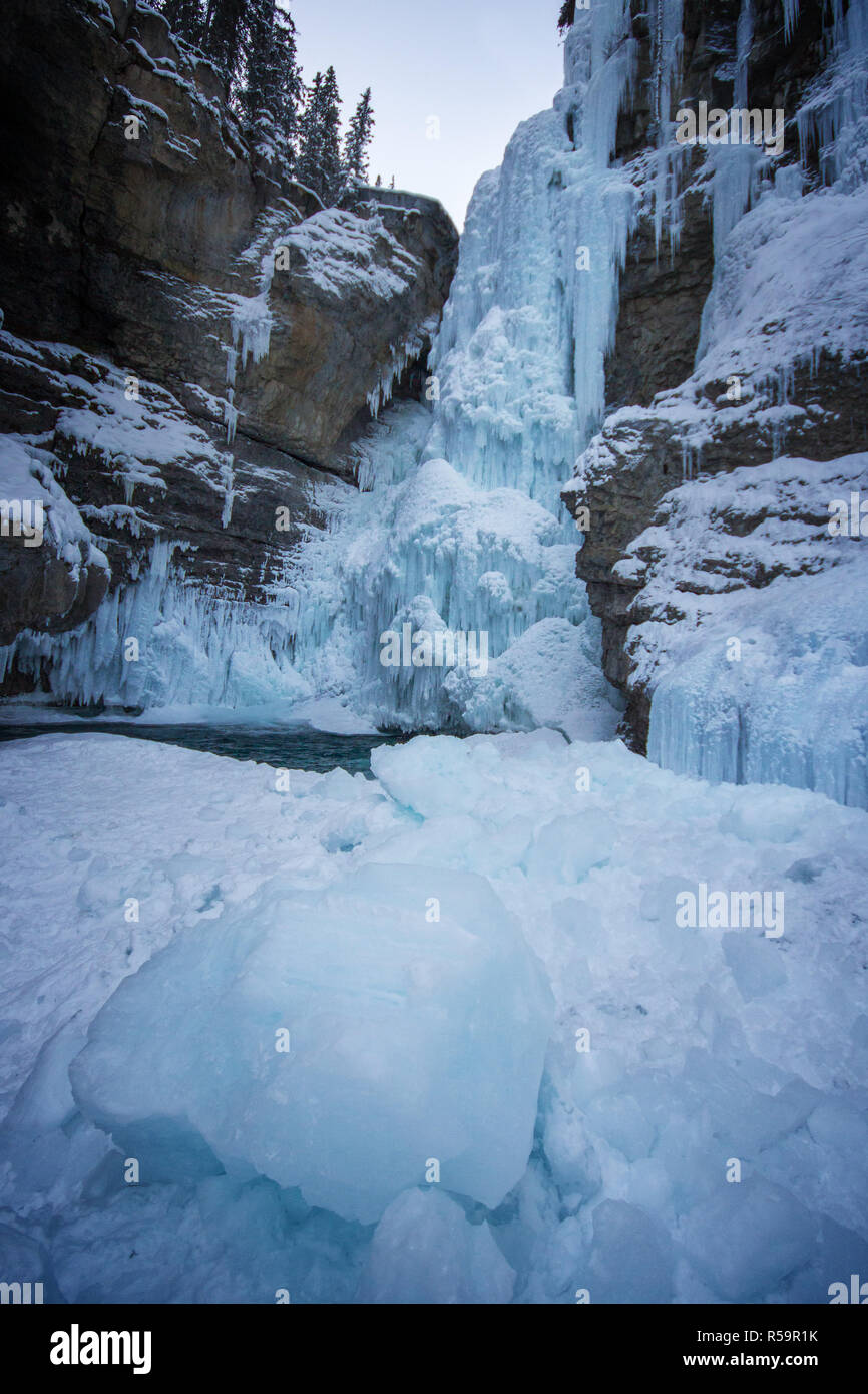 Long frozen waterfall with icy walls of canyon and big piece of ice in ...