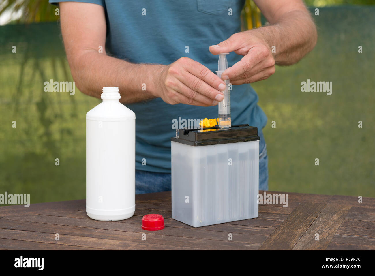Filling a battery with acid Stock Photo - Alamy