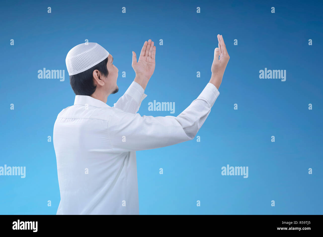 Religious muslim man raising hand and praying Stock Photo - Alamy