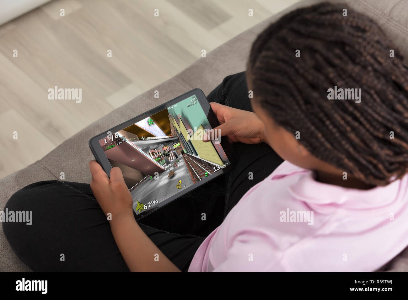 Girl Playing Video Game On Digital Tablet Stock Photo - Alamy