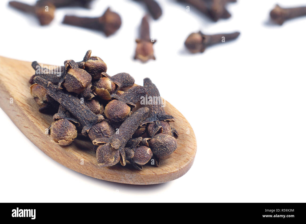 Cloves spices in wooden spoon on white background close up Stock Photo ...