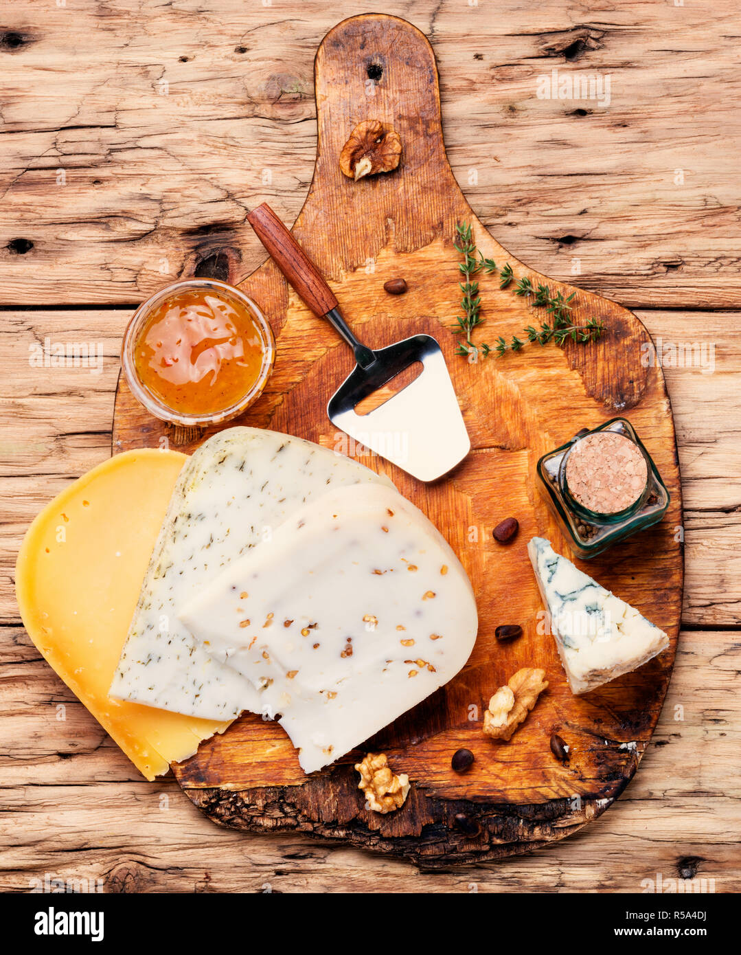 Wooden board with different kinds of cheese on table Stock Photo - Alamy