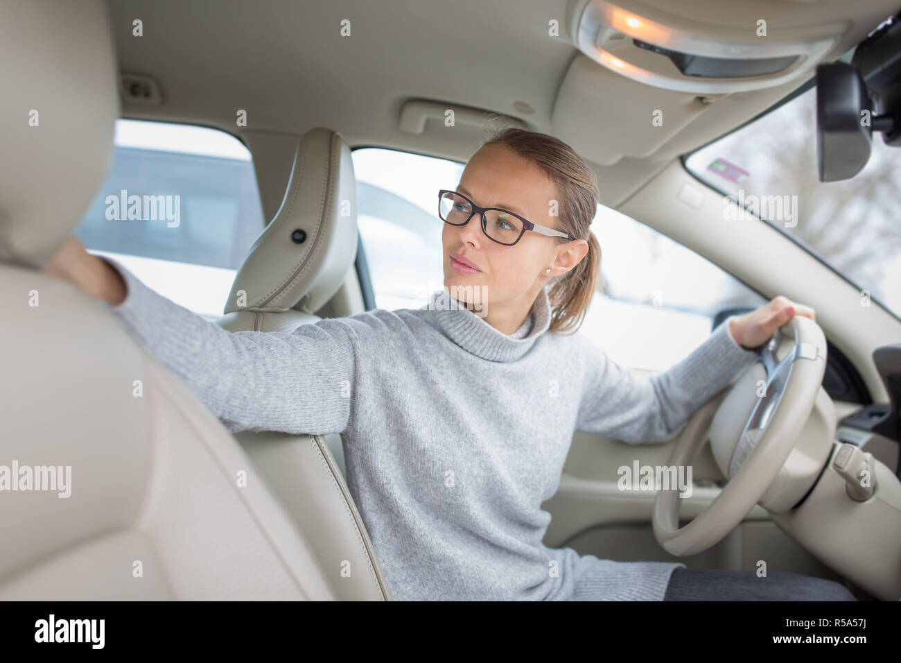 Woman driving a car - female driver at a wheel of a modern car, parking ...