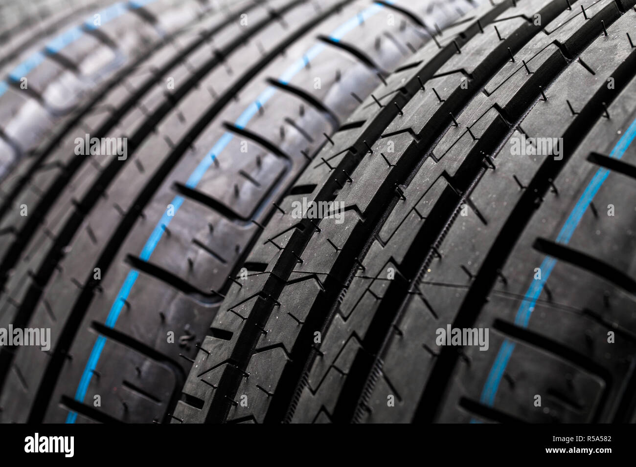 Stack of brand new high performance car tires on clean high-key white ...