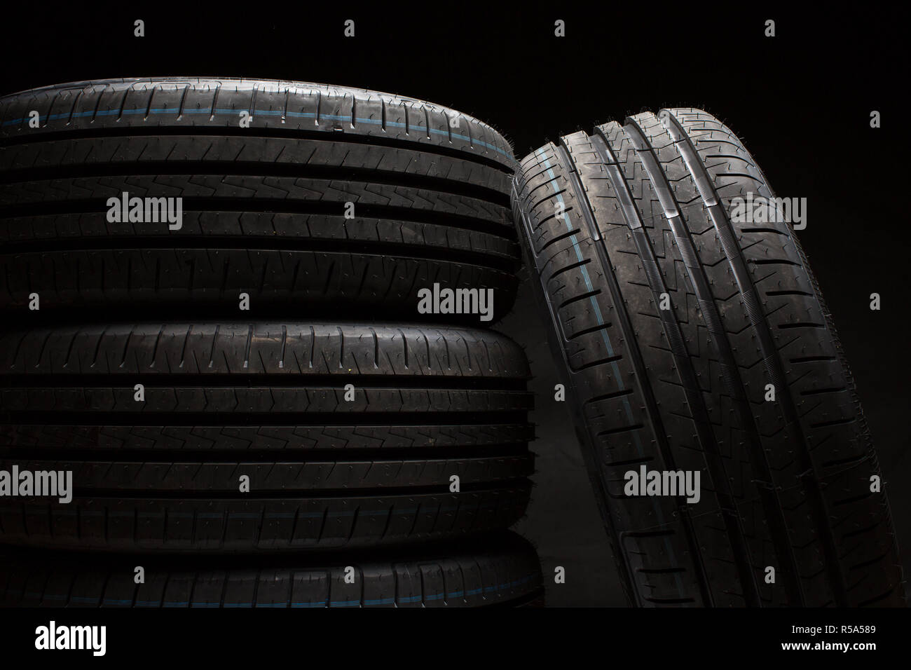 Stack of brand new high performance car tires on clean high-key white ...