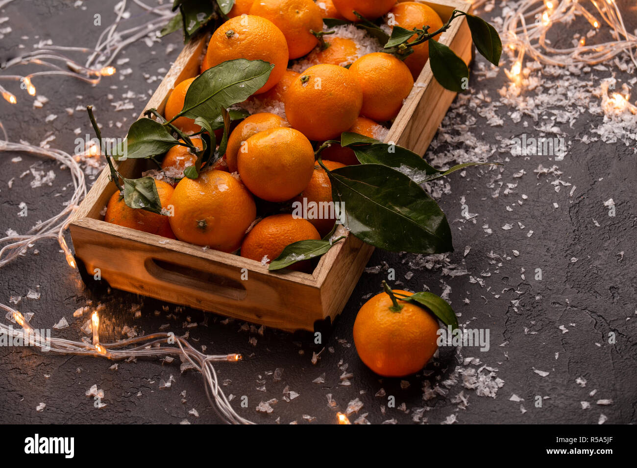 Image of tangerines in wooden box with burning garland Stock Photo - Alamy