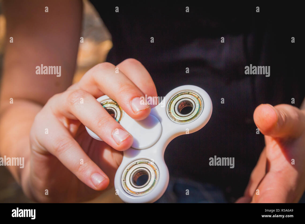 Young girl play with fidget spinner Stock Photo - Alamy