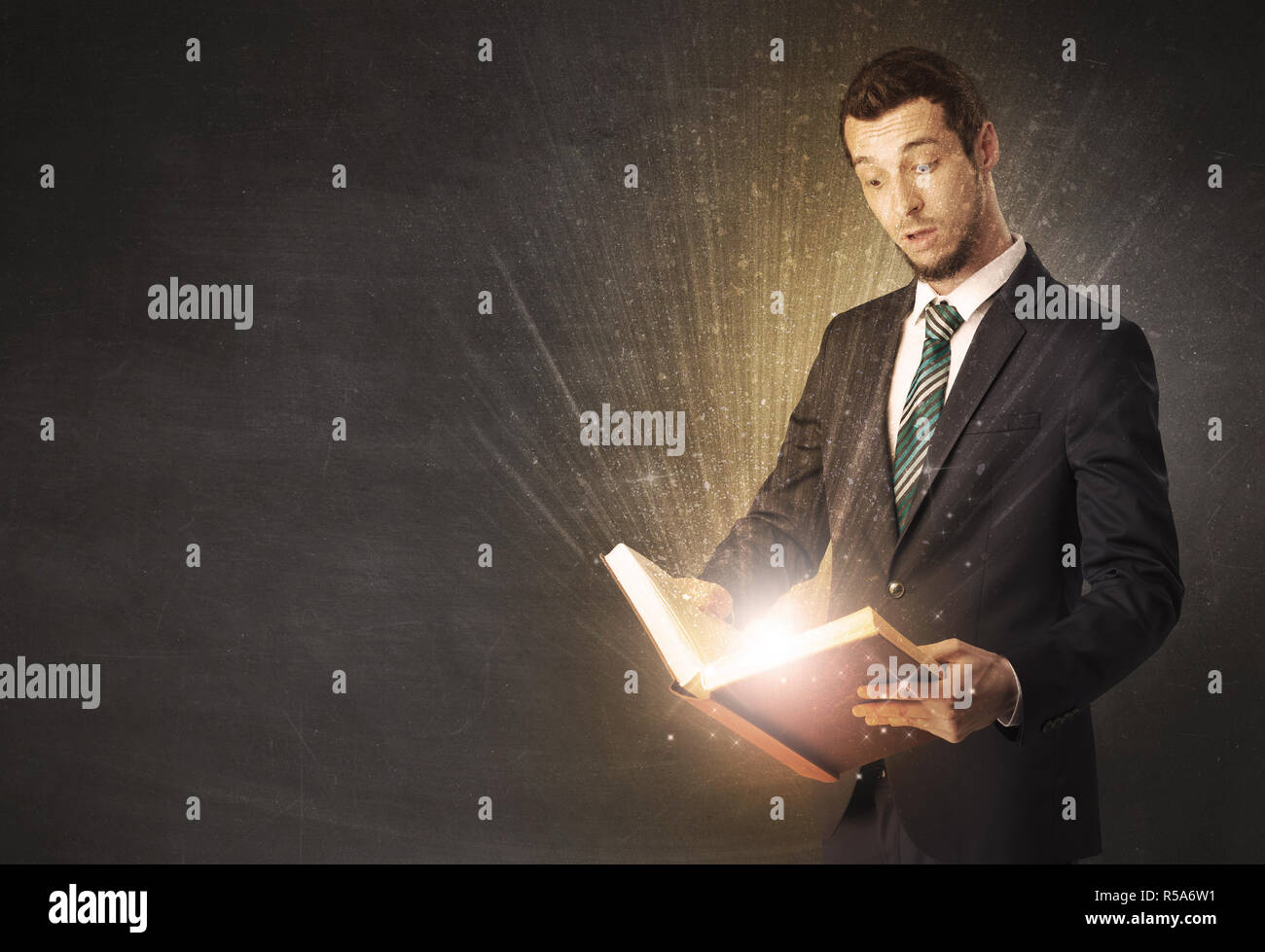 Man holding and reading a shiny book Stock Photo - Alamy