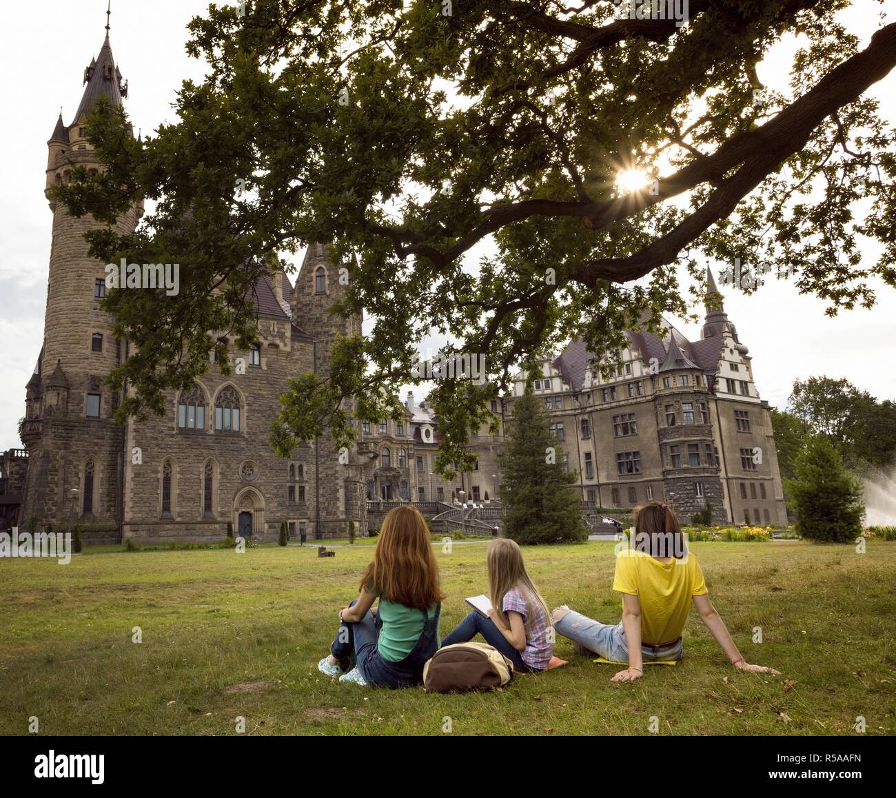 Happy family - mom and two daughters are sitting in a meadow Beautiful ...