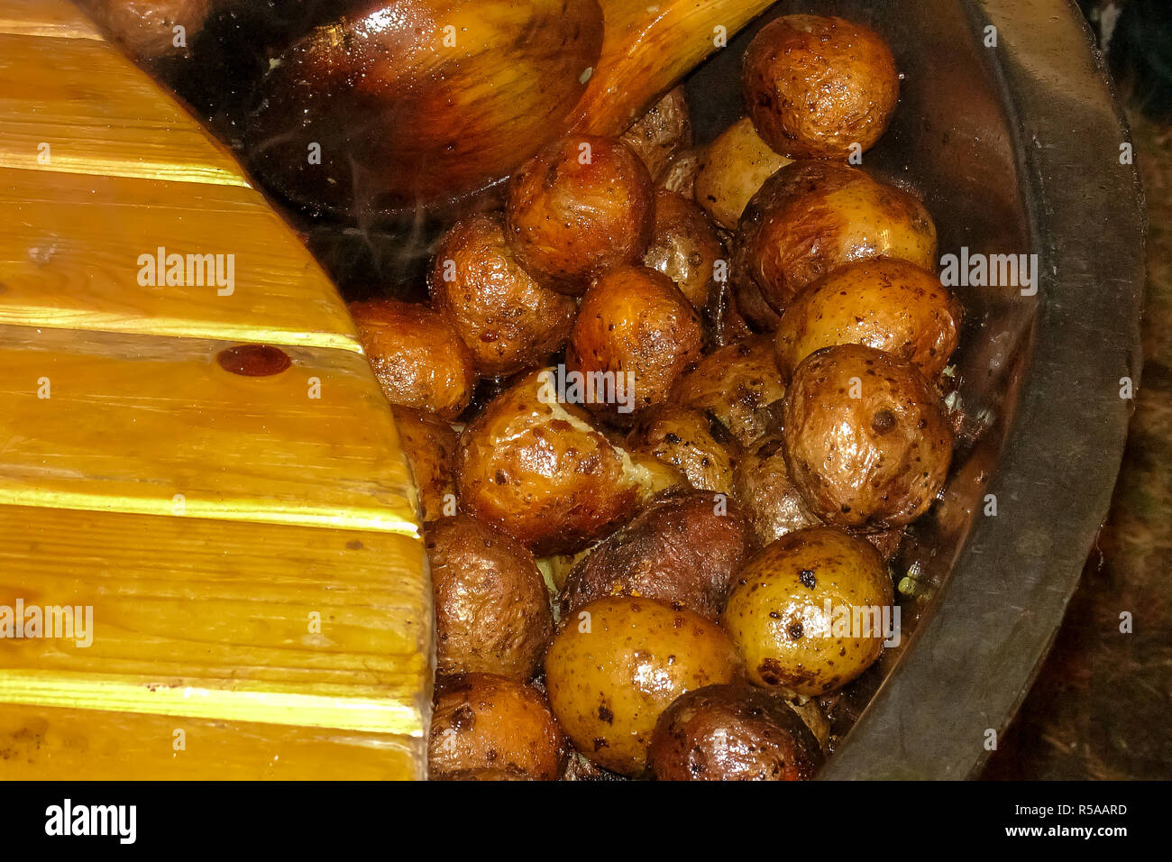 Fried potatoes with the peel. Potatoes fried in a pan on the bonfire ...