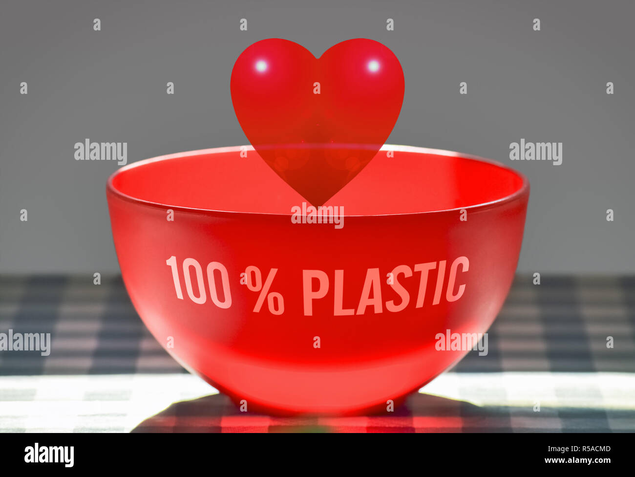 Plastic heart in a plastic bowl symbolizing fake love Stock Photo - Alamy