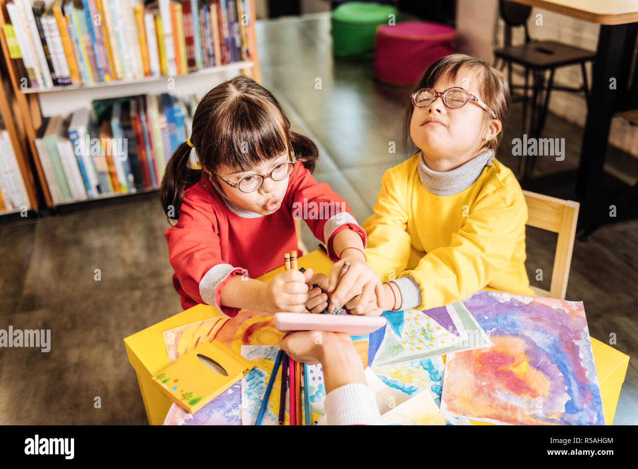 Playing tricks. Dark-haired sunny children wearing glasses playing ...