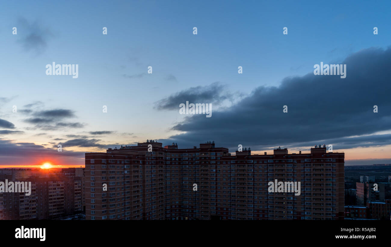 Sun rising over city Stock Photo - Alamy