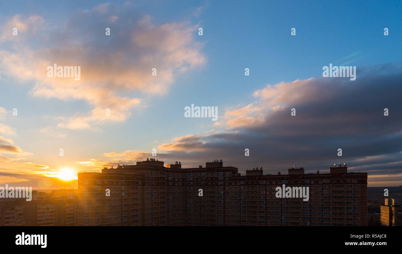 Sun rising over city Stock Photo - Alamy