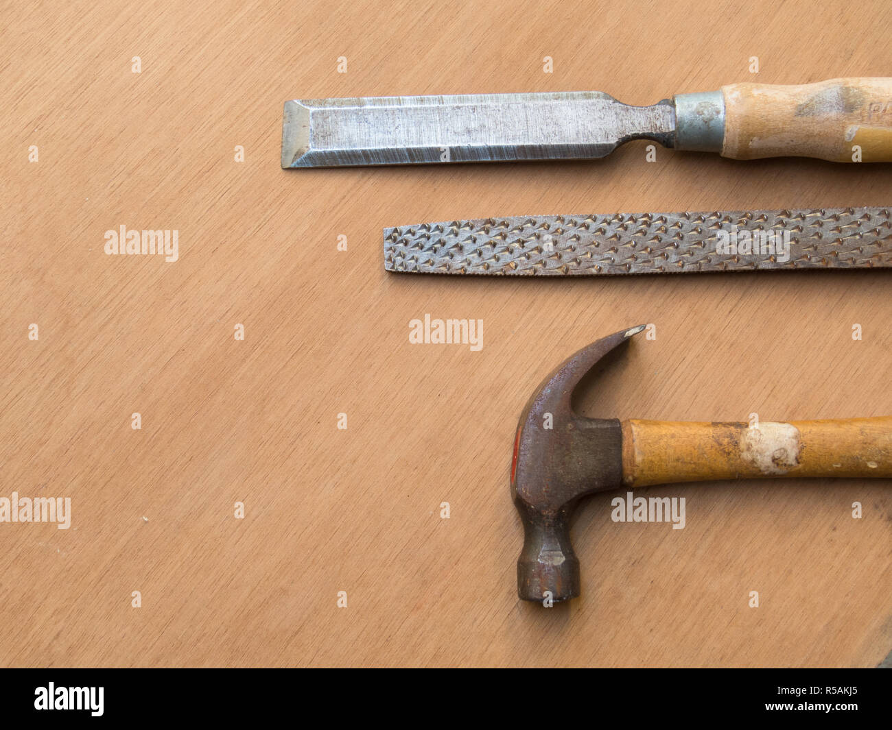 Hammer, rasp and chisel for carpentry, on wooden table Stock Photo - Alamy