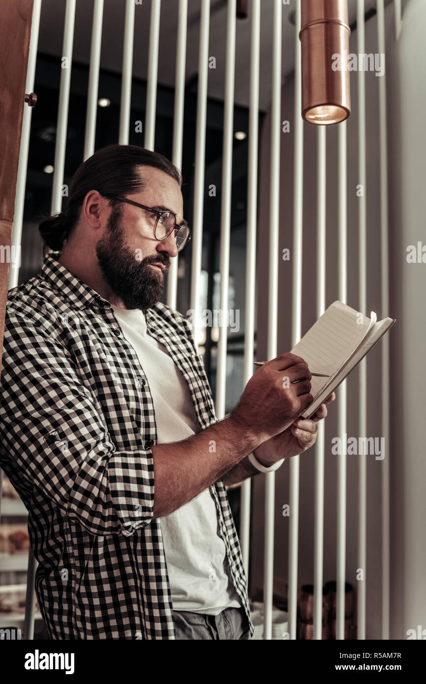 Not to forget. Serious nice man standing near the window while taking ...