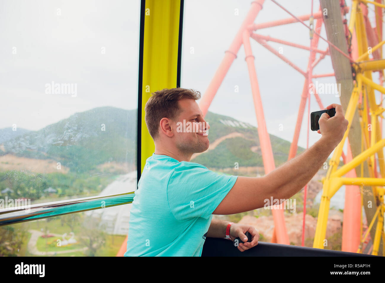 Ferris wheel man makes selfie young guy Stock Photo - Alamy