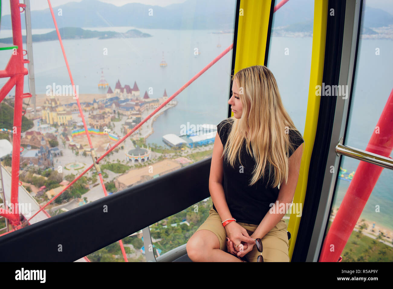 the girl sits in the booth of the Ferris wheel Stock Photo - Alamy