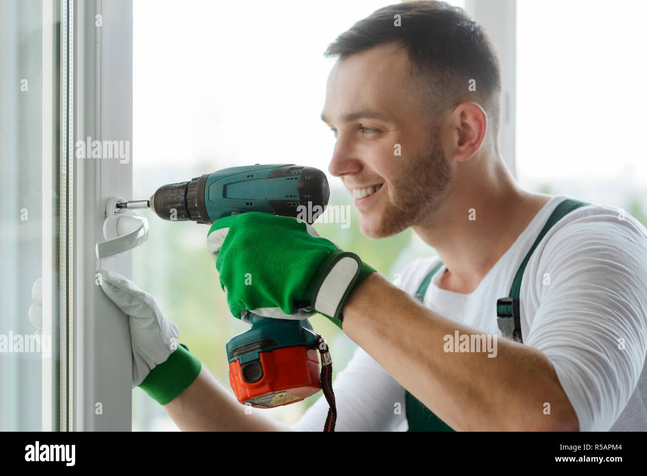 Worker installing a window handle Stock Photo - Alamy