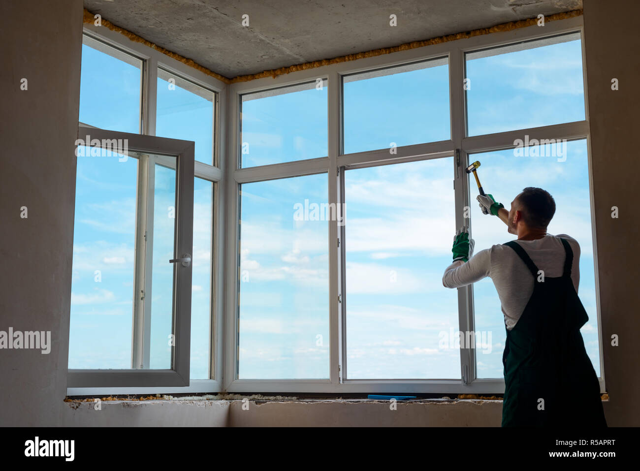 Builder is installing a window Stock Photo - Alamy