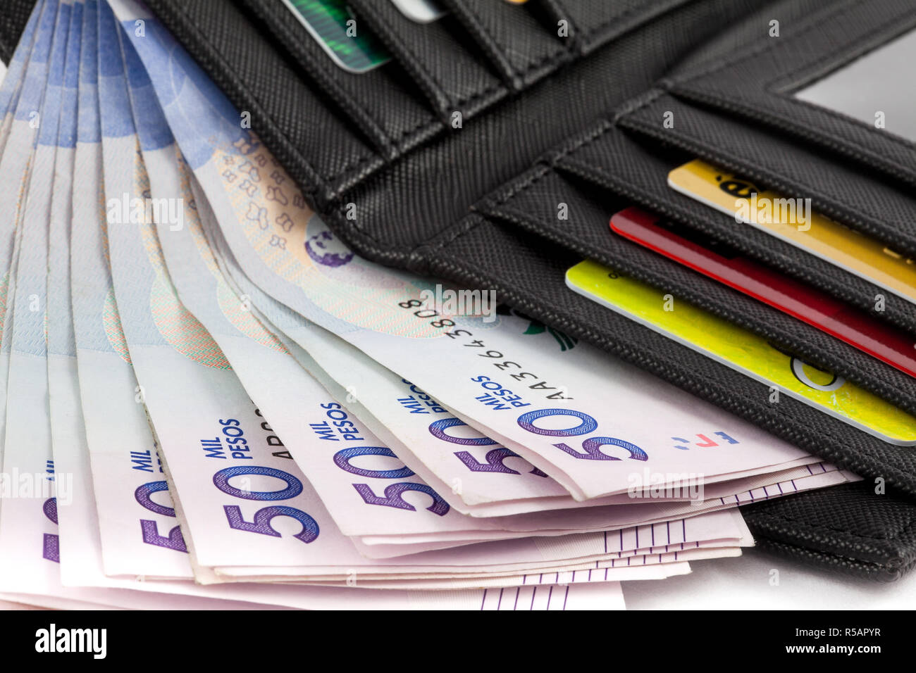 Black wallet filled with money and cards Stock Photo - Alamy