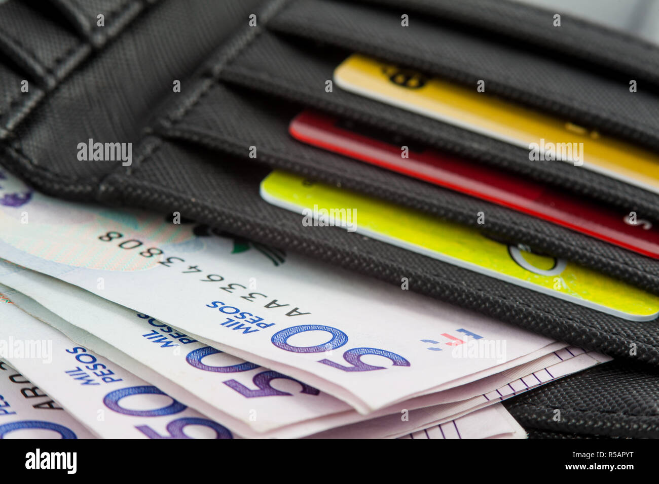 Black wallet filled with money and cards Stock Photo - Alamy