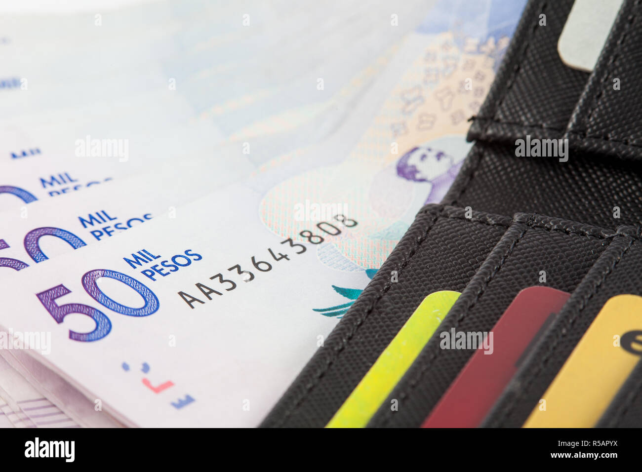 Black wallet filled with money and cards Stock Photo - Alamy