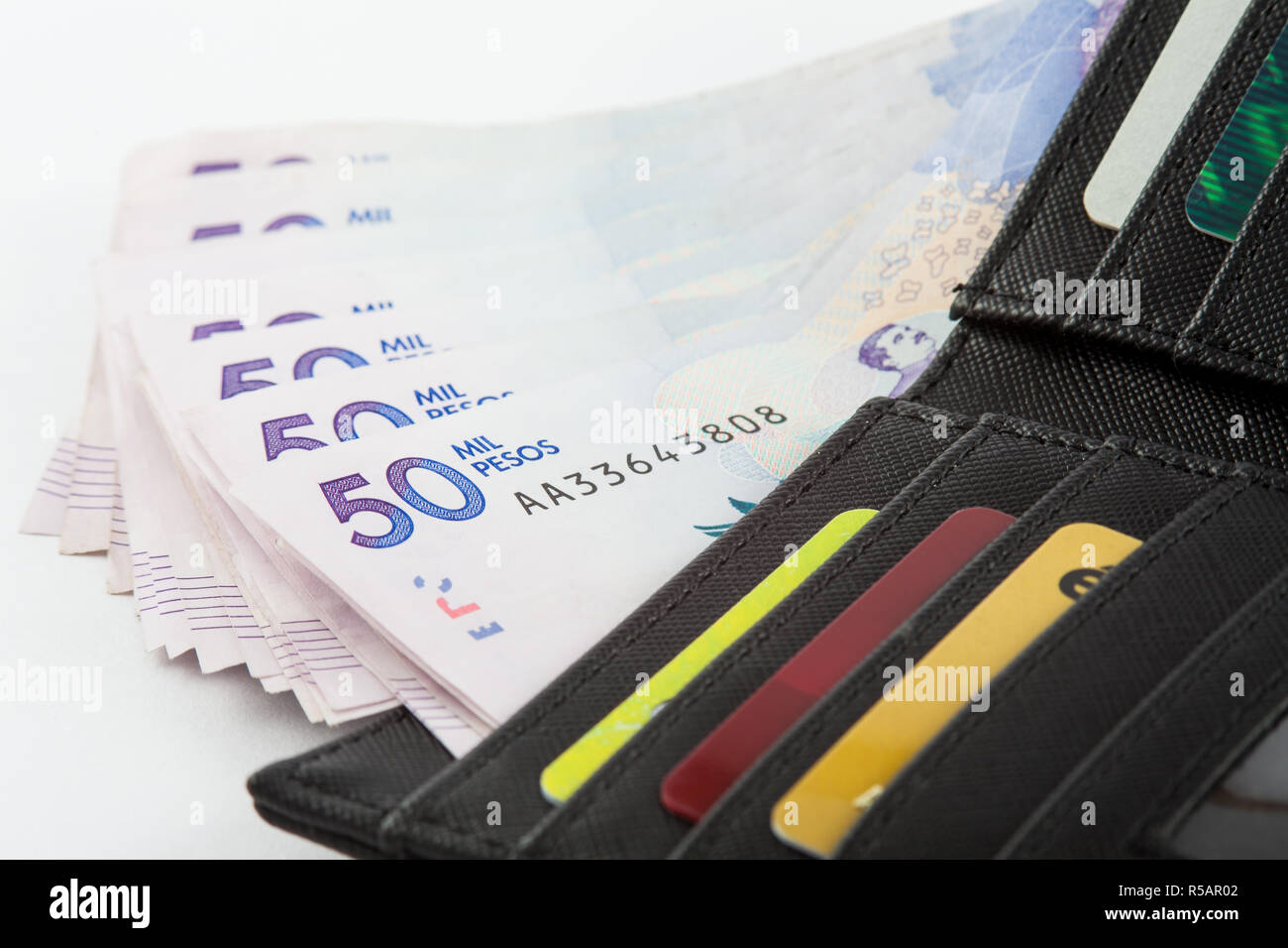 Black wallet filled with money and cards Stock Photo - Alamy