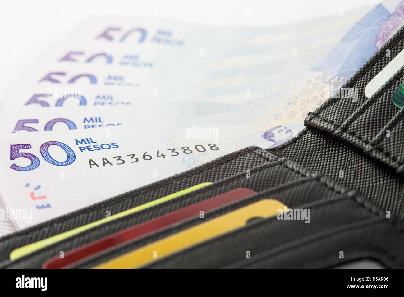 Black wallet filled with money and cards Stock Photo - Alamy