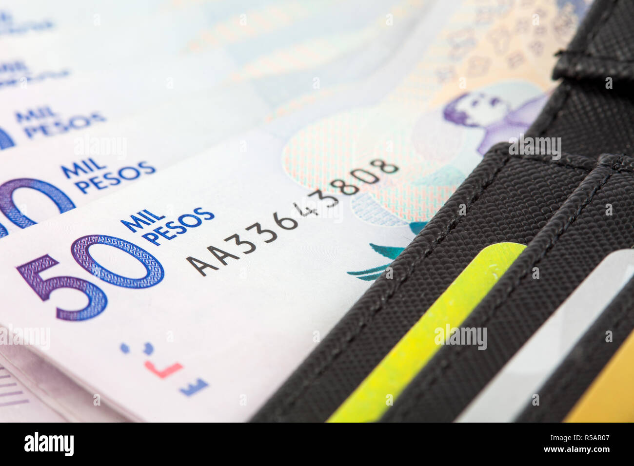 Black wallet filled with money and cards Stock Photo - Alamy