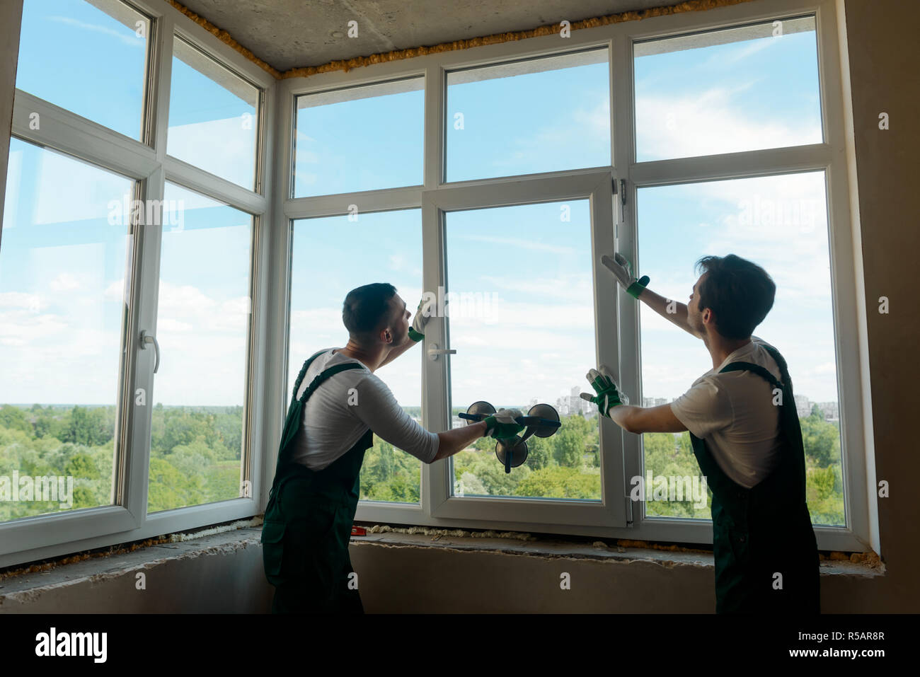 Men are installing a window Stock Photo - Alamy