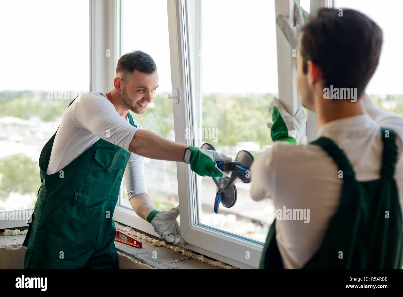 Construction workers installing a window Stock Photo - Alamy